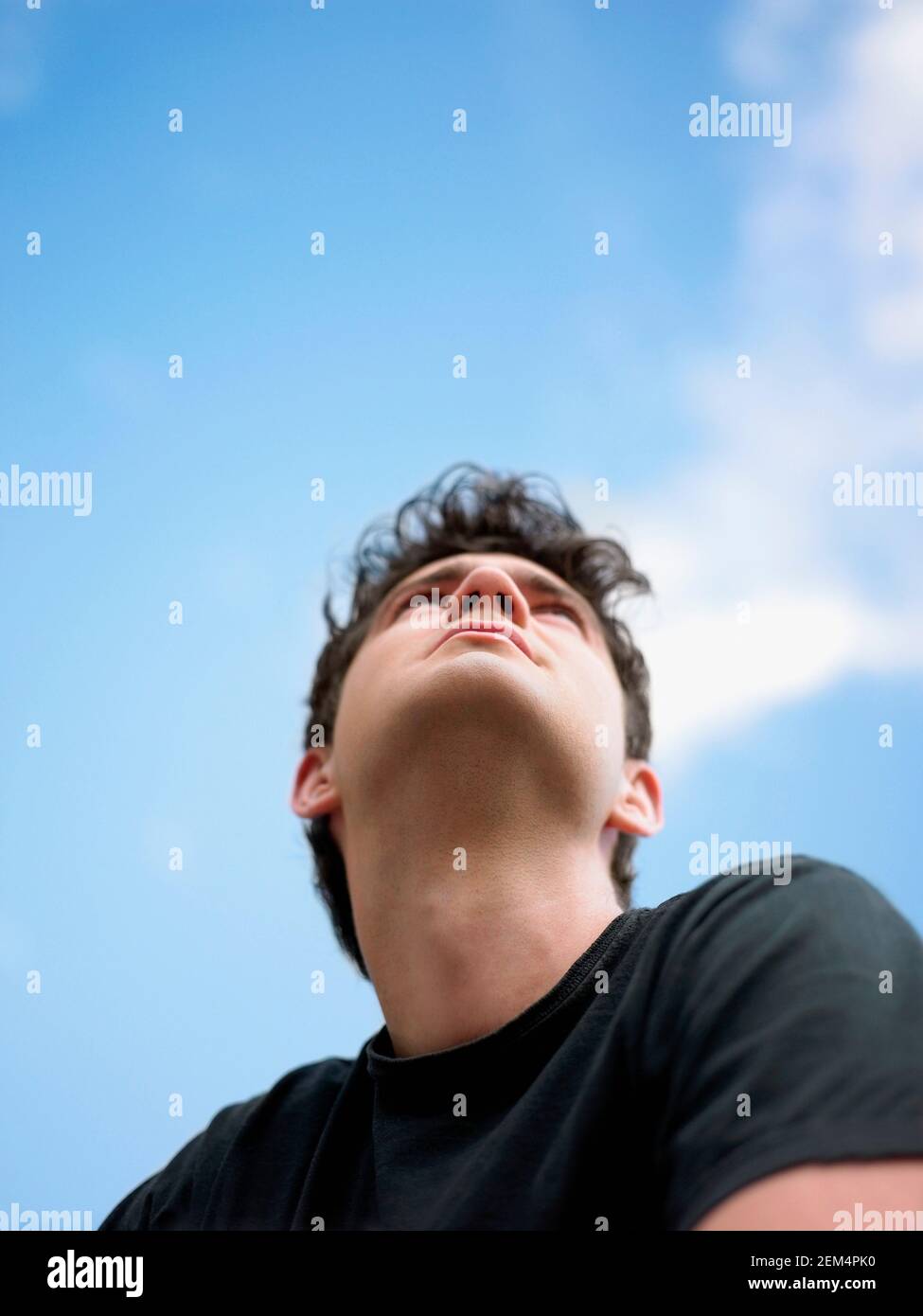 Low angle view of a young man looking up and thinking Stock Photo - Alamy