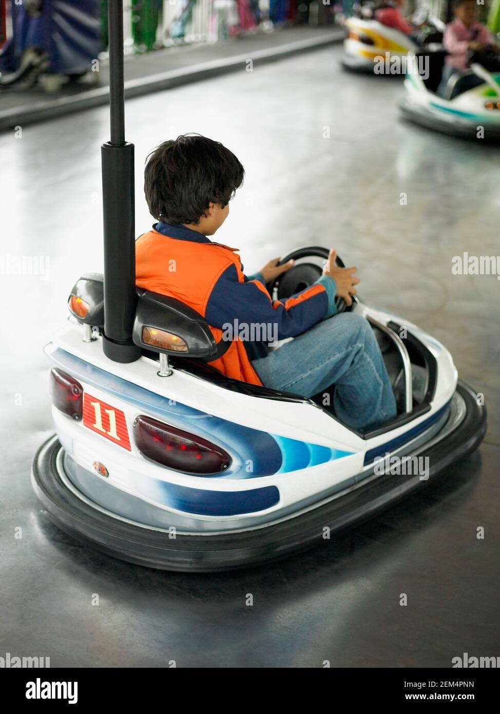 Rear view of a boy riding a bumper car Stock Photo - Alamy