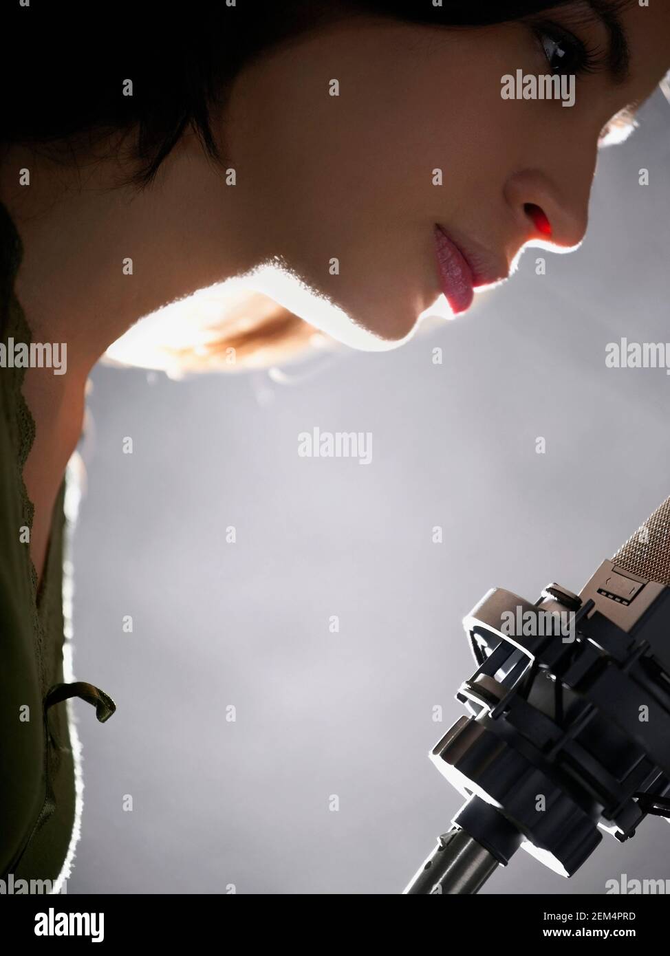 Side profile of a young woman with a microphone Stock Photo - Alamy