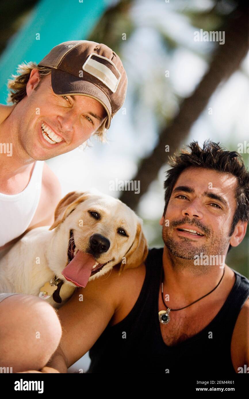 Portrait of two mid adult men with a dog Stock Photo - Alamy