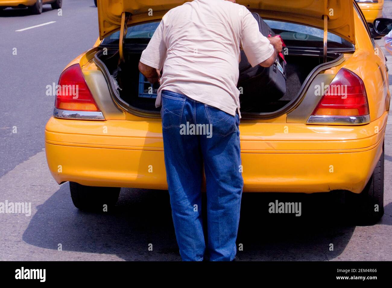 Rear view of a man loading luggage in a car Stock Photo - Alamy