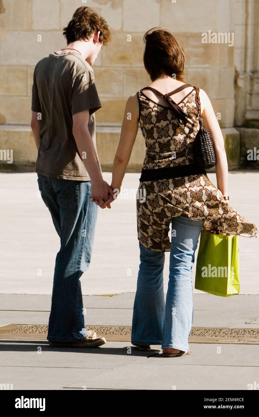 Rear view of a couple holding hands Stock Photo - Alamy