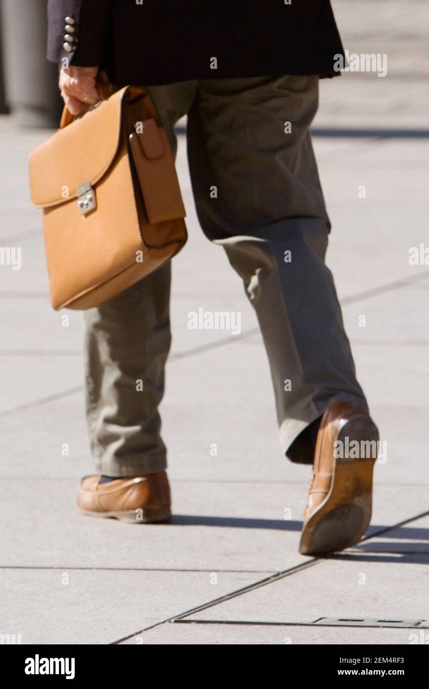 Low section view of a businessman carrying a briefcase Stock Photo - Alamy