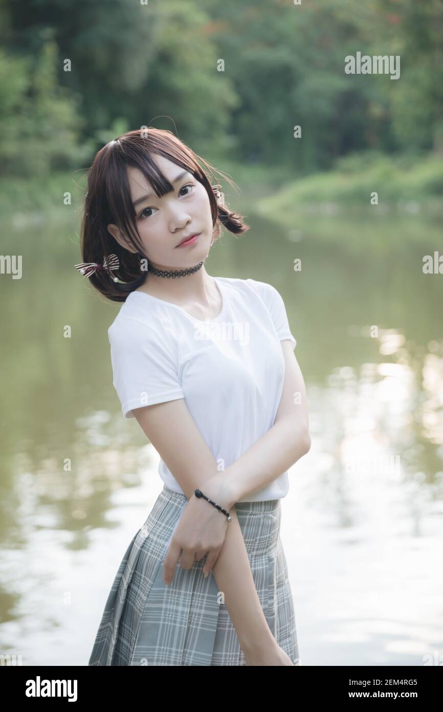 portrait of asian girl with white shirt and skirt looking in outdoor ...