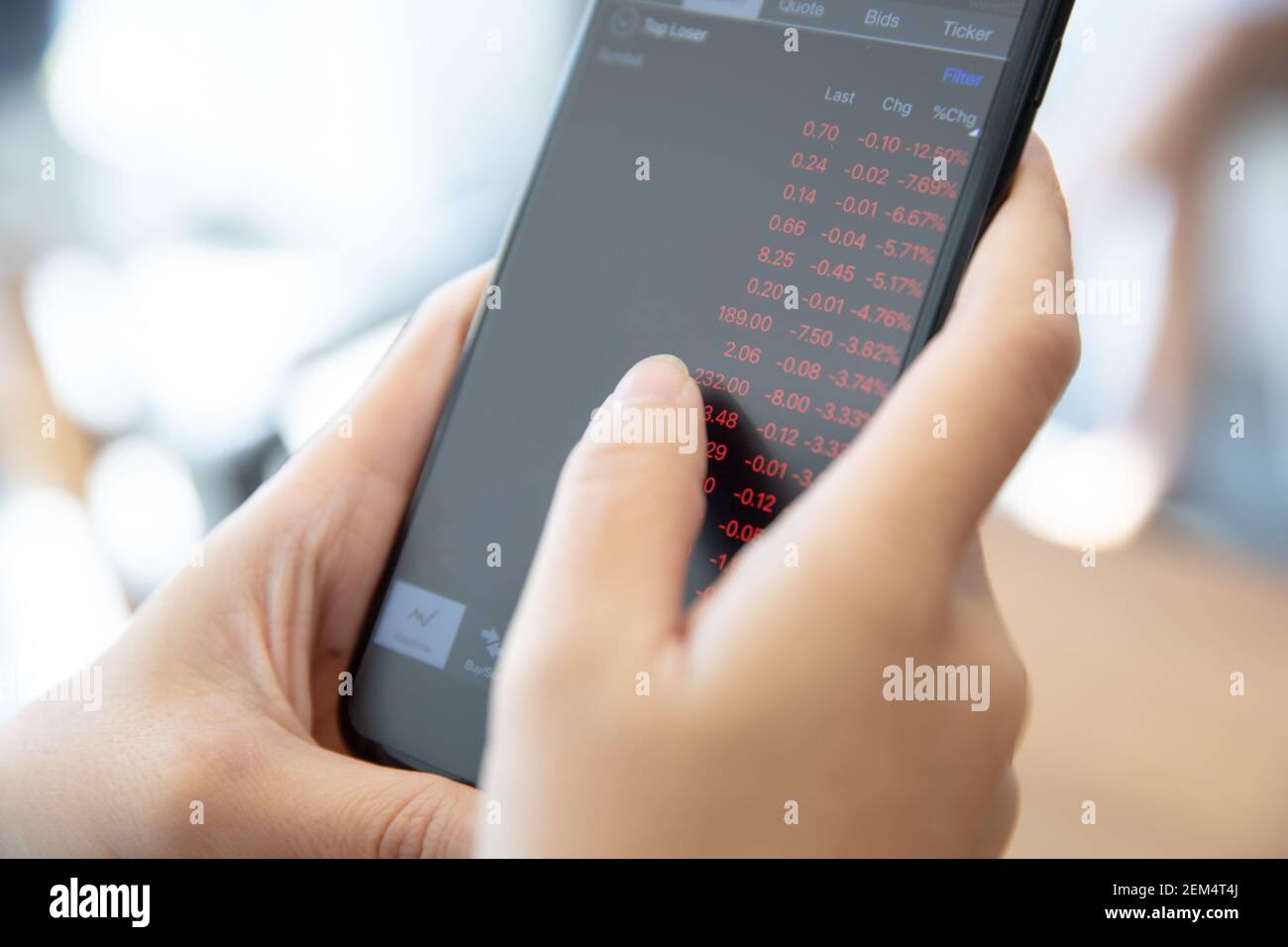 Female hand with smartphone trading stock online in coffee shop ...