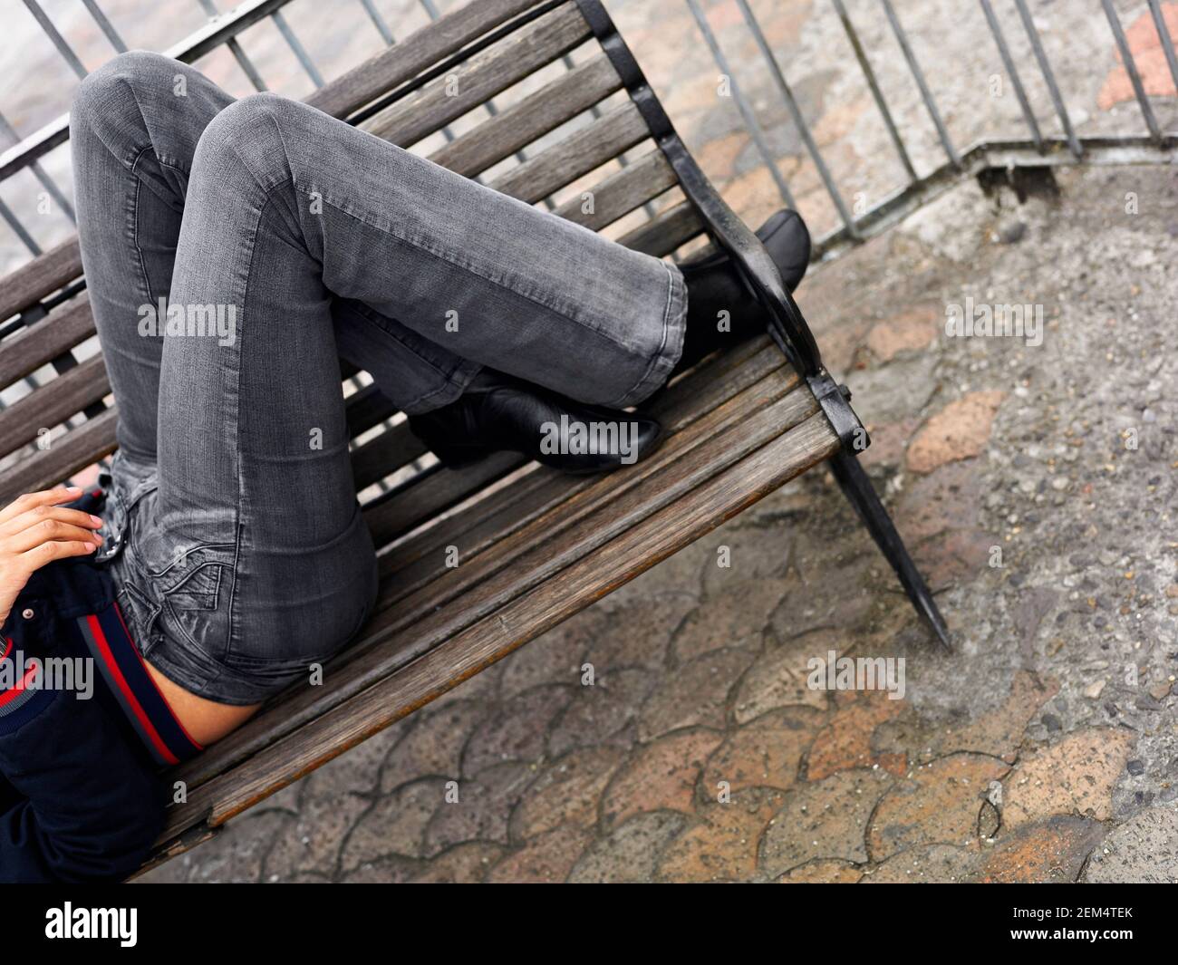 Low section view of a young woman lying on a bench Stock Photo - Alamy