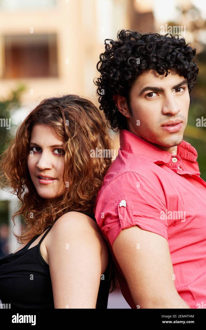 Portrait of a young couple back to back Stock Photo - Alamy