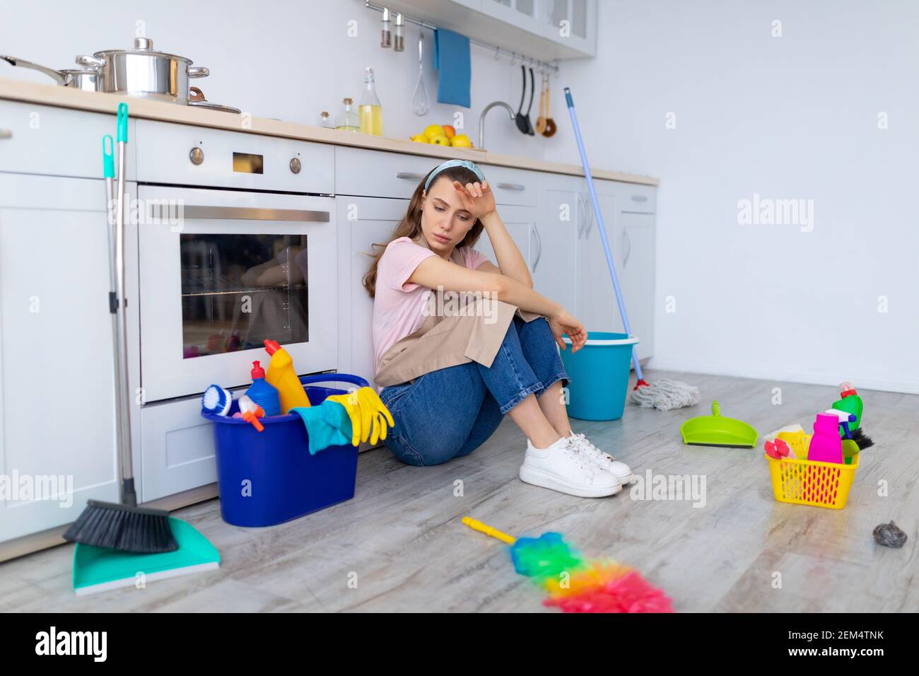 Depressed young housewife feeling tired from domestic chores, sitting ...
