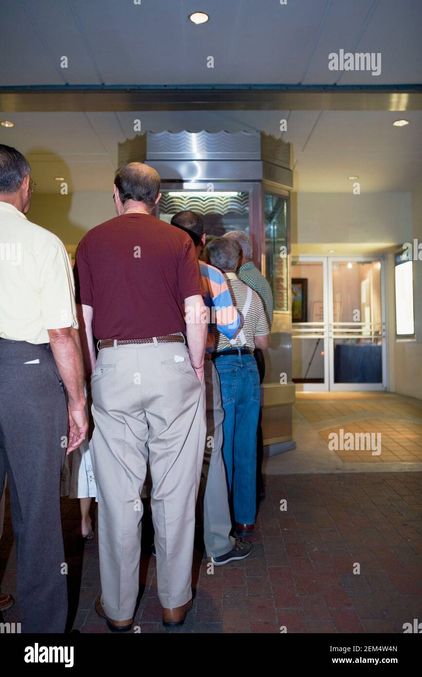 Group of people standing in a queue in front of a ticket counter Stock ...