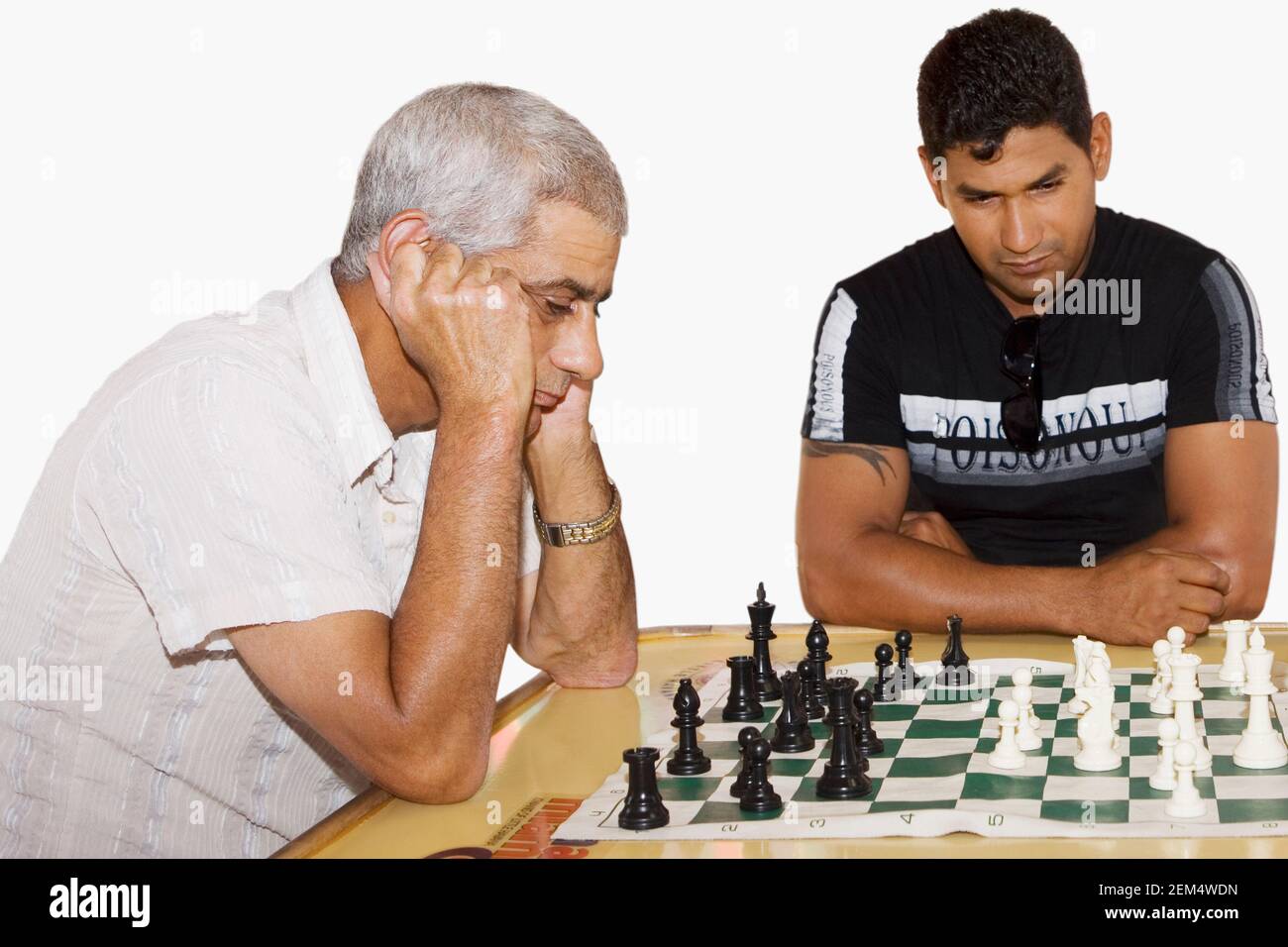 Side profile of a senior man playing chess and a young man looking at ...