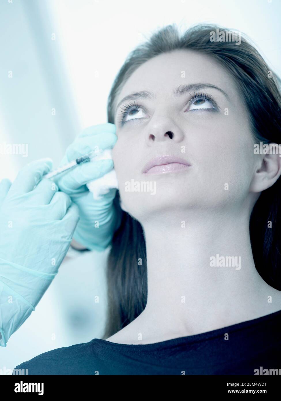 Close-up of a mid adult woman getting a botox injection on her face ...