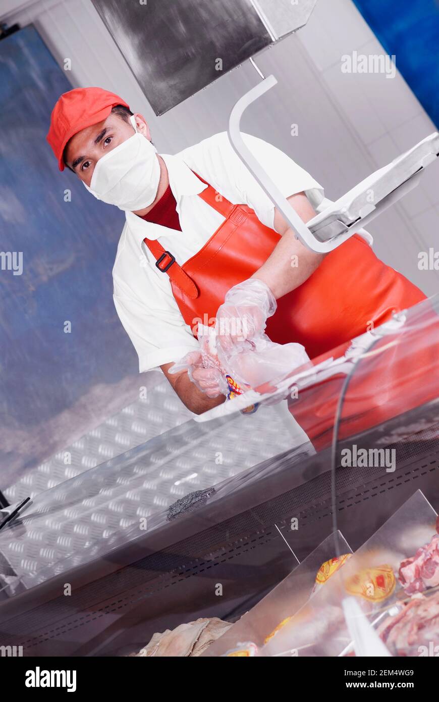 Portrait of a butcher packing meat in a butcher shop Stock Photo - Alamy
