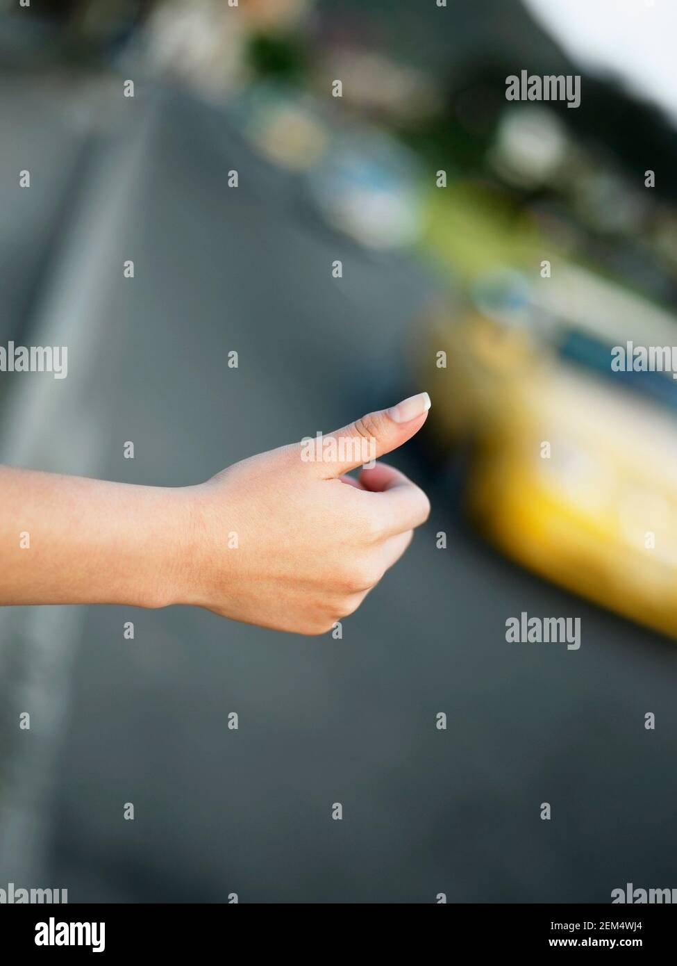 Close-up of a woman's hand making a hitchhiking sign Stock Photo - Alamy