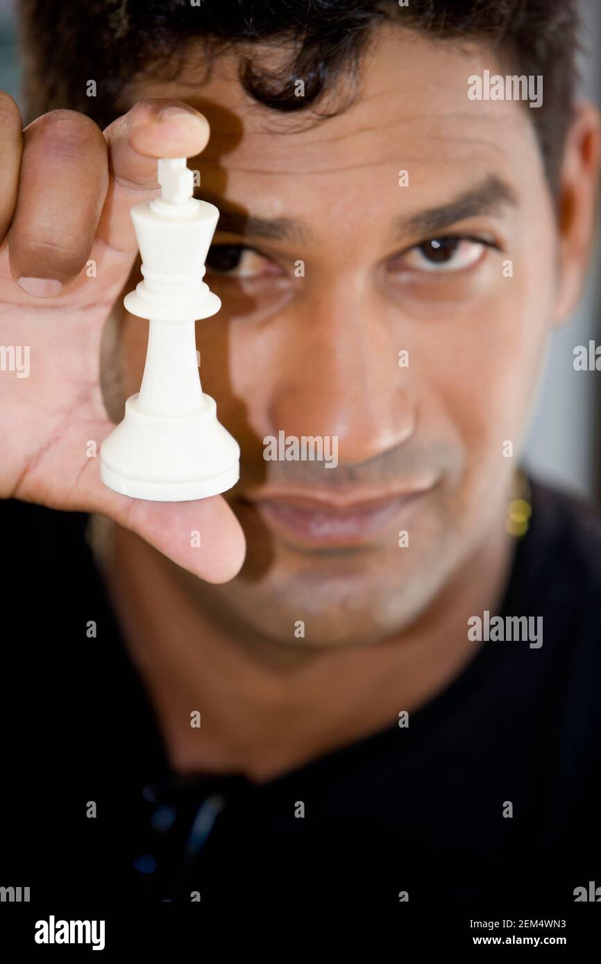 Portrait of a young man showing a chess piece Stock Photo - Alamy