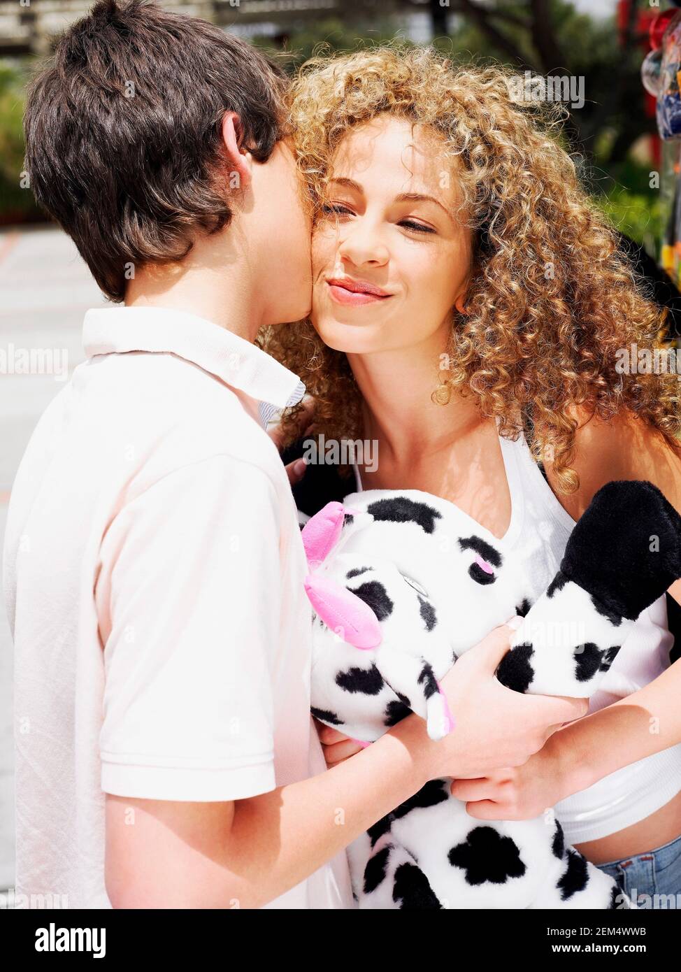 Side profile of a young man kissing a teenage girl Stock Photo - Alamy
