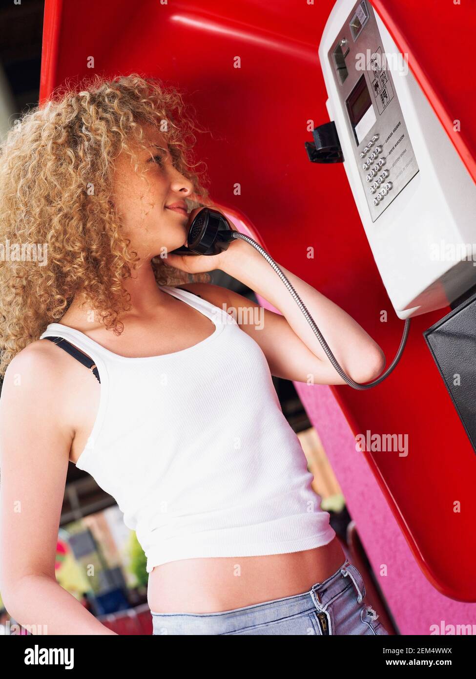 Close-up of a teenage girl talking on a pay phone Stock Photo - Alamy