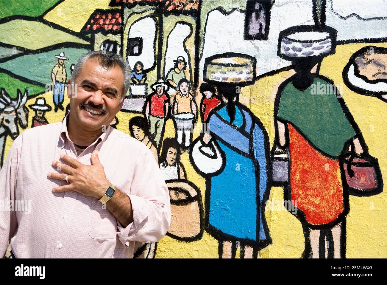 Portrait of a mature man standing in front of a graffiti wall and ...