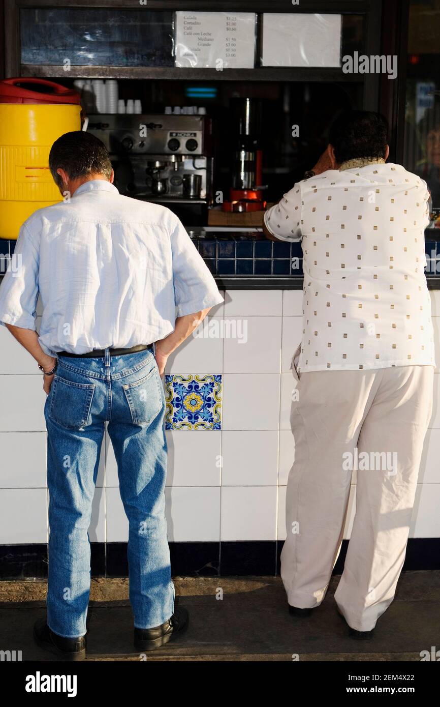 Rear view of two mature men standing at a cafe checkout counter Stock ...