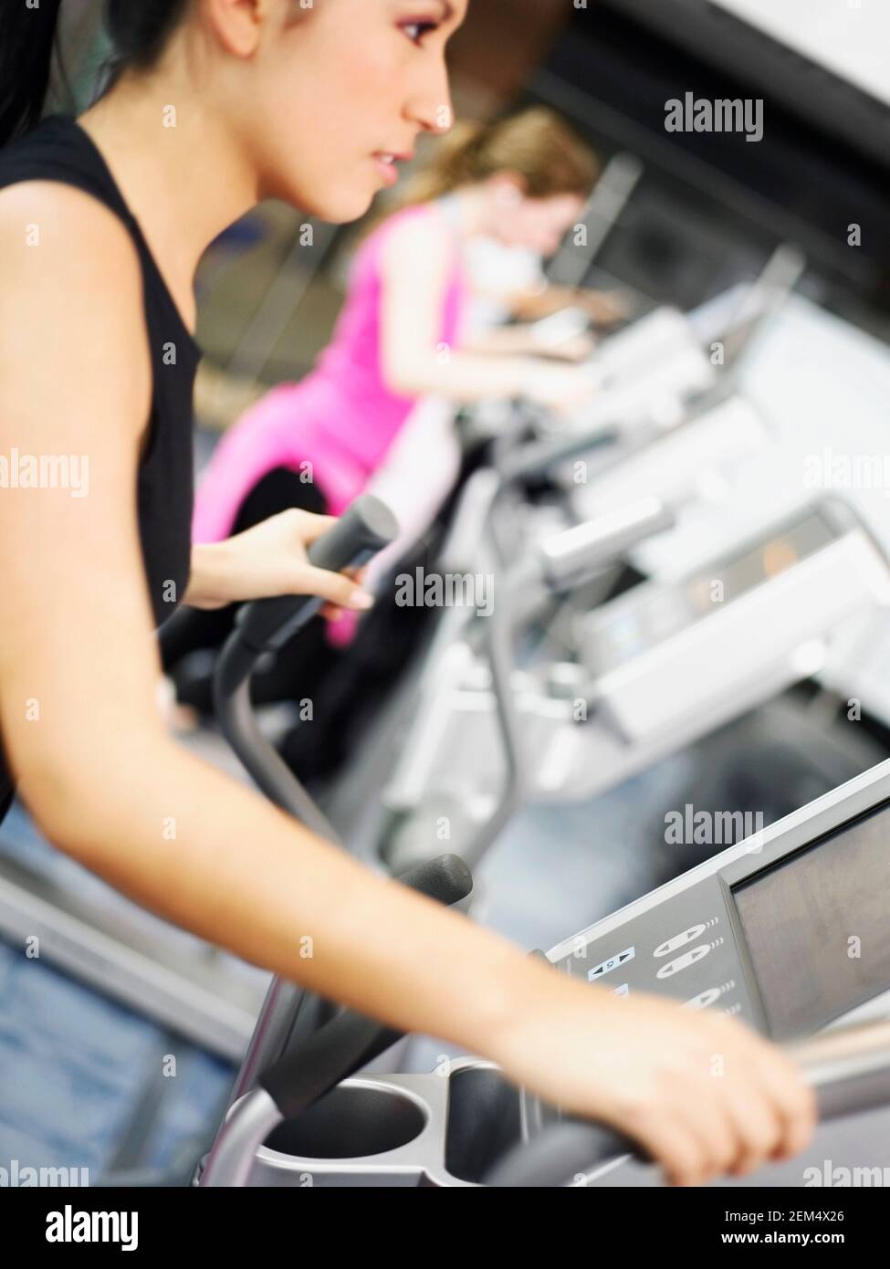 Side profile of a young woman exercising on a treadmill Stock Photo - Alamy