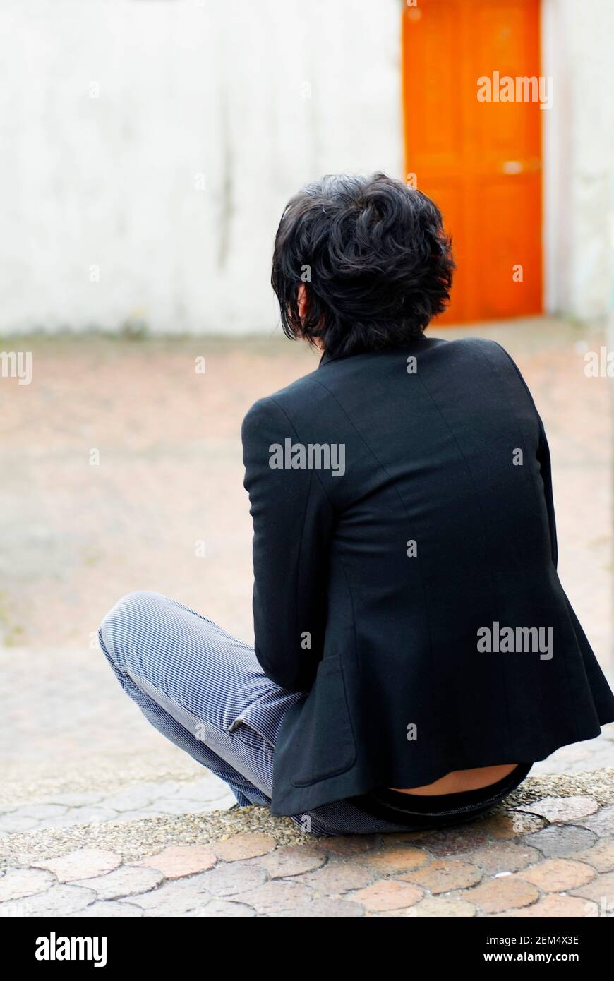 Rear view of a young man sitting Stock Photo - Alamy