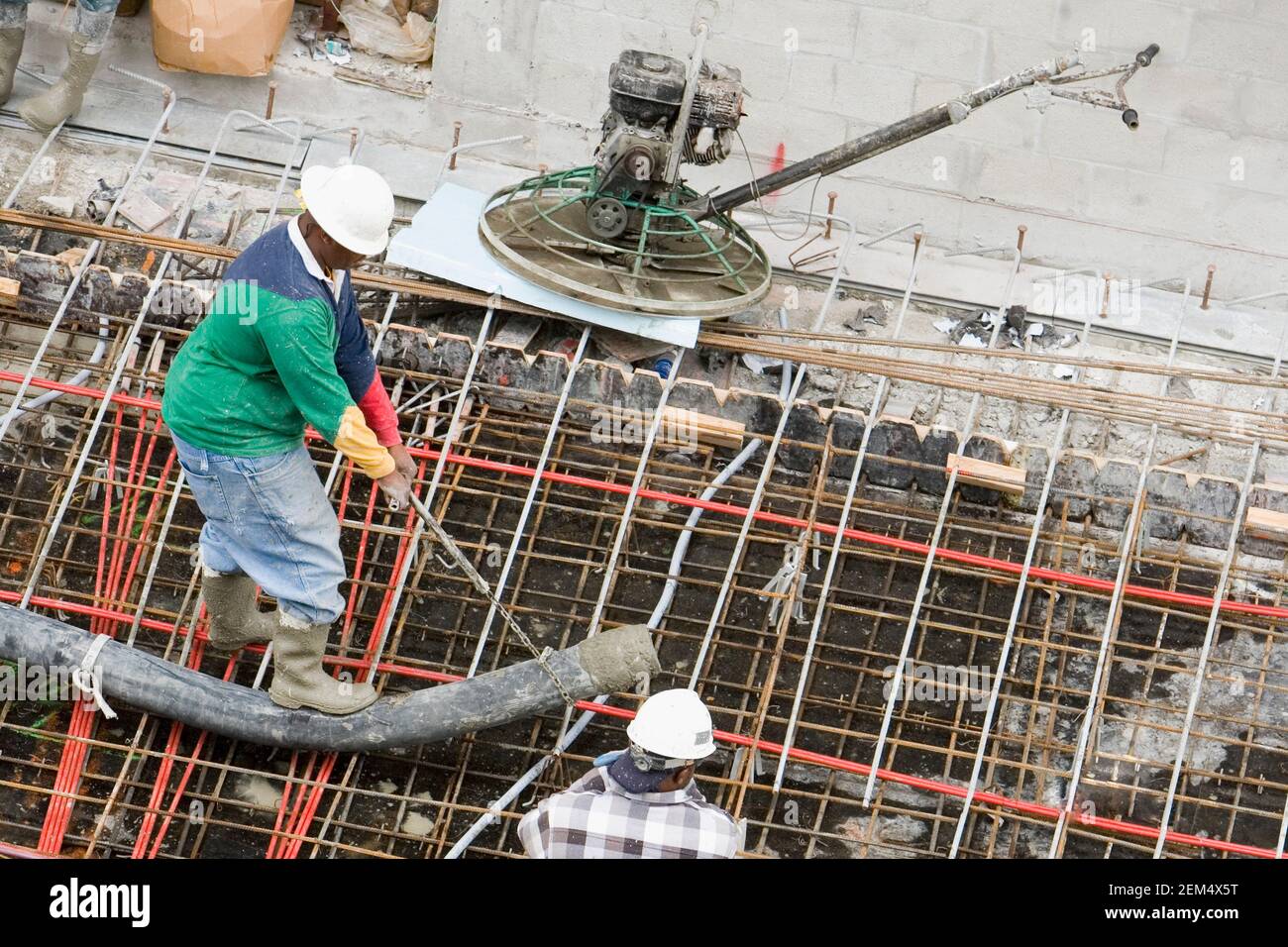 Rear view of two construction workers working at construction site hi ...