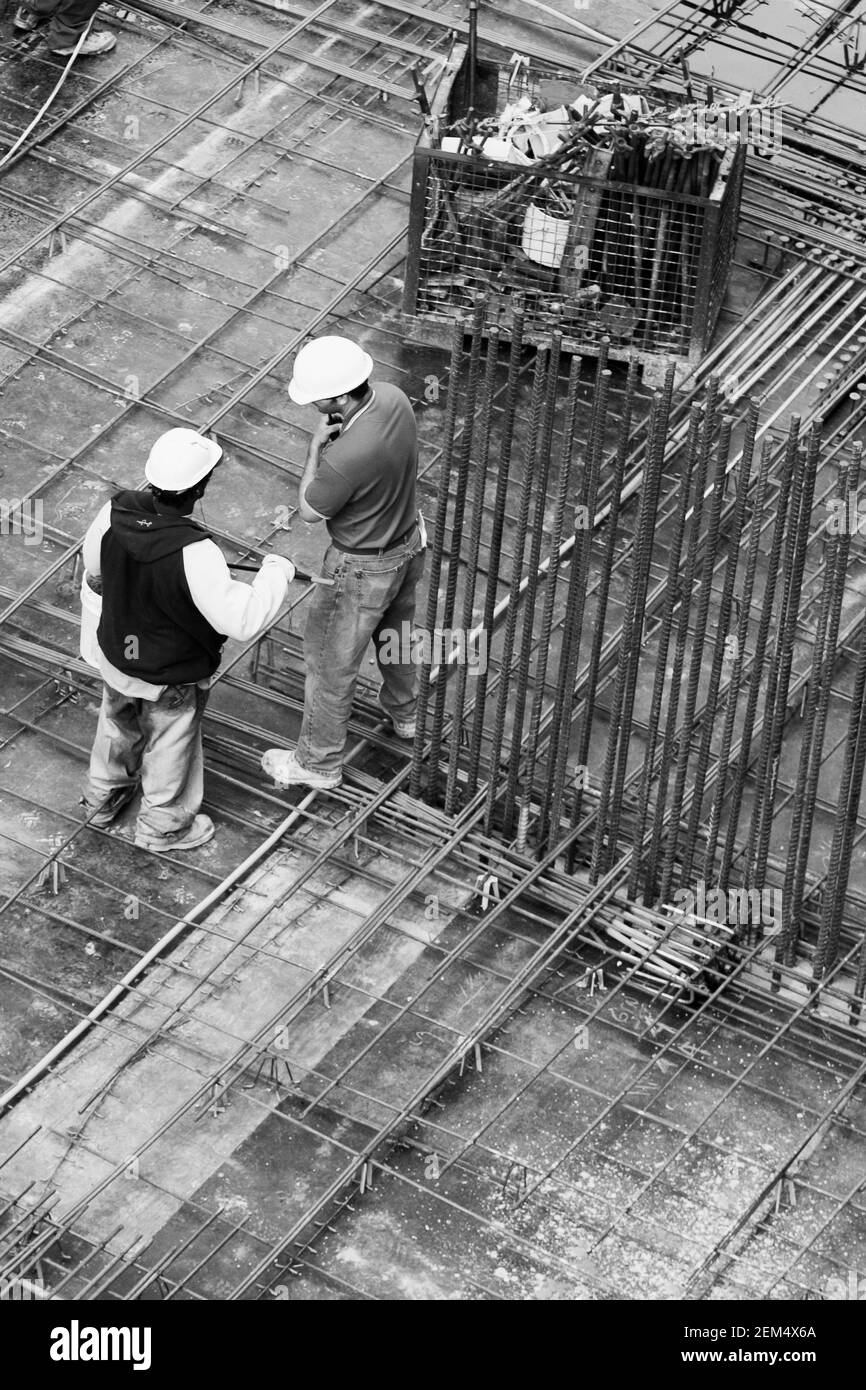 Rear view of two construction workers working at construction site ...