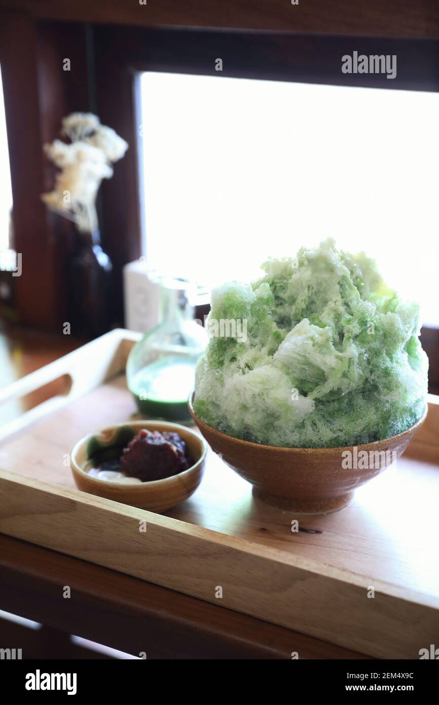 Delicious Japanese sweet shaved ice green tea on wooden table in ...