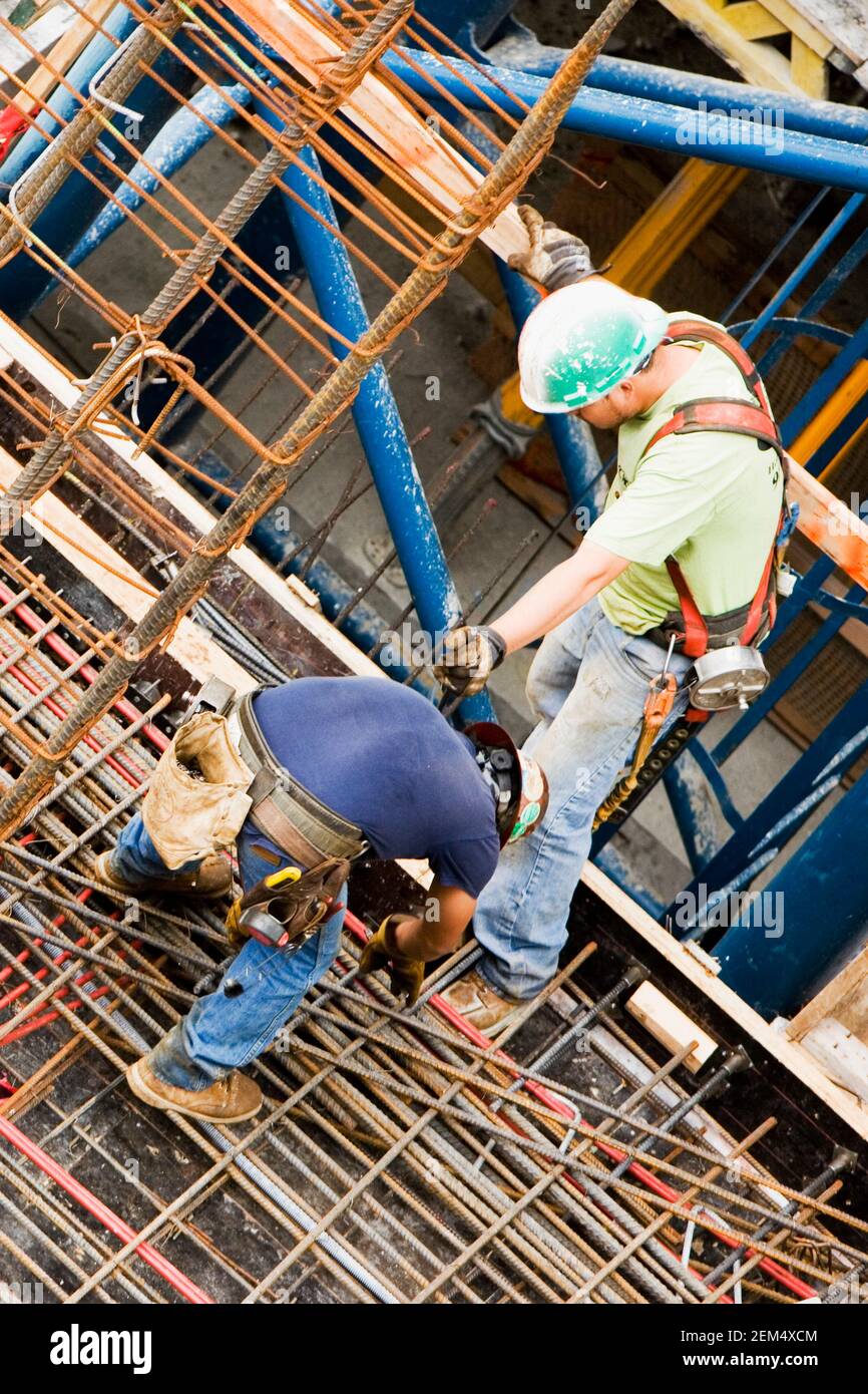 High angle view of two construction workers working at a construction ...