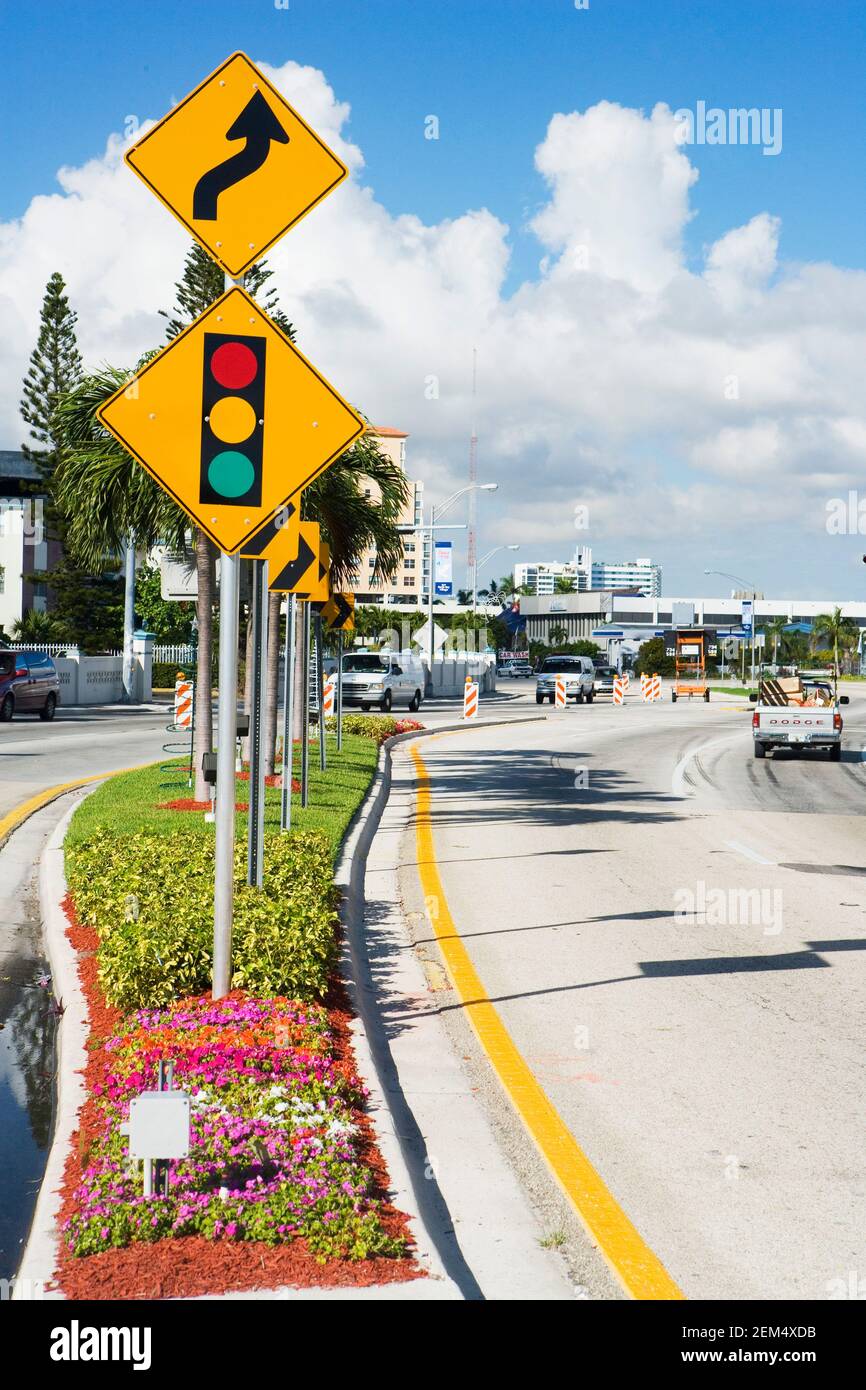 Double bend sign with a spotlight sign on the roadside Stock Photo - Alamy