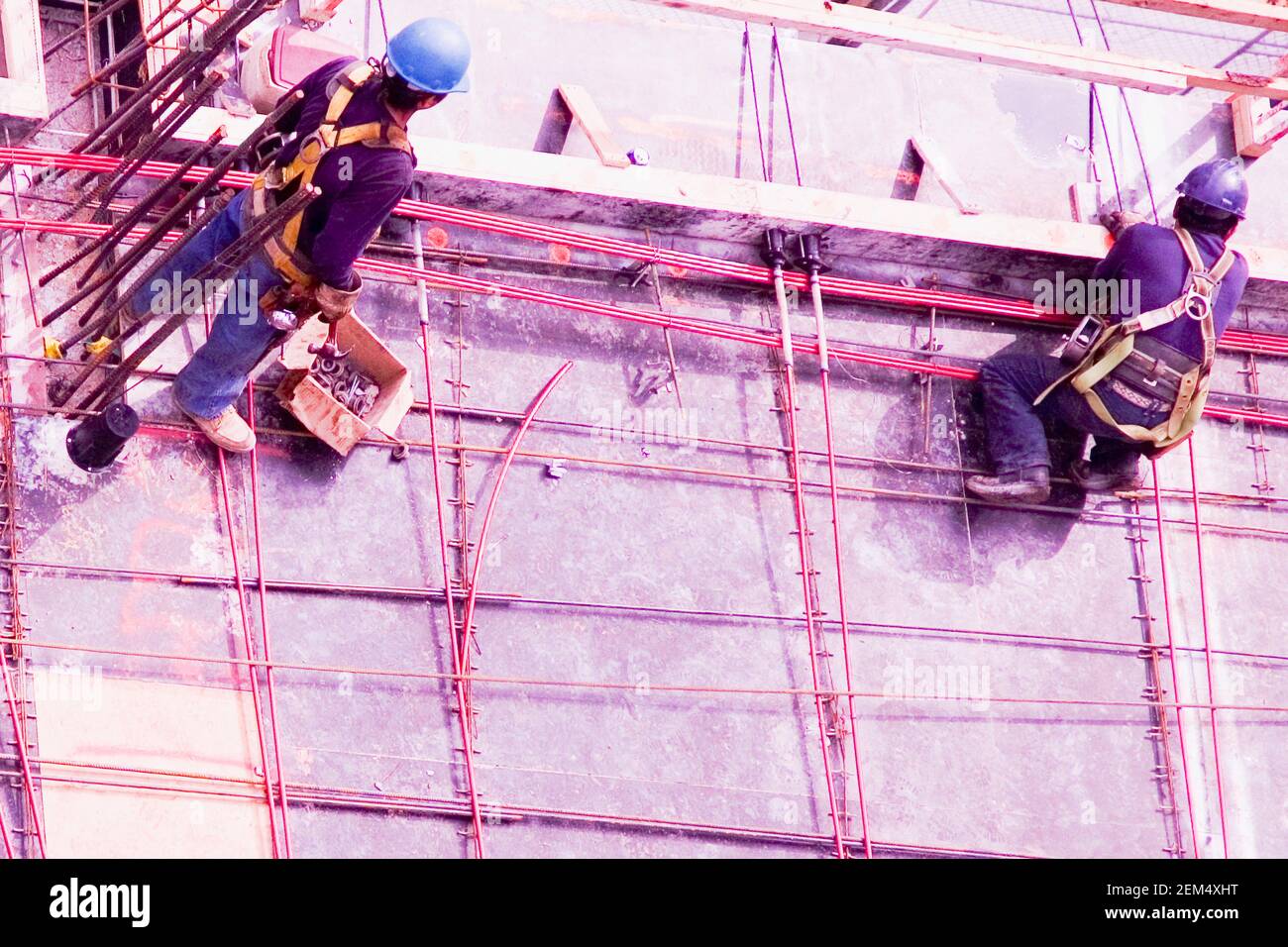 Rear view of two construction workers working at construction site hi ...