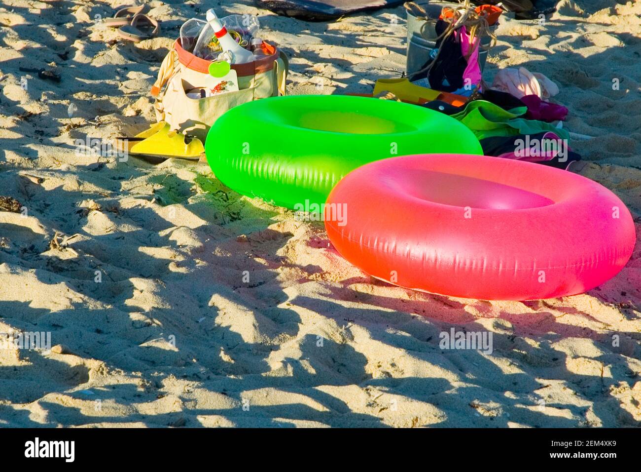 Two inflatable rings and bags on the beach Stock Photo - Alamy