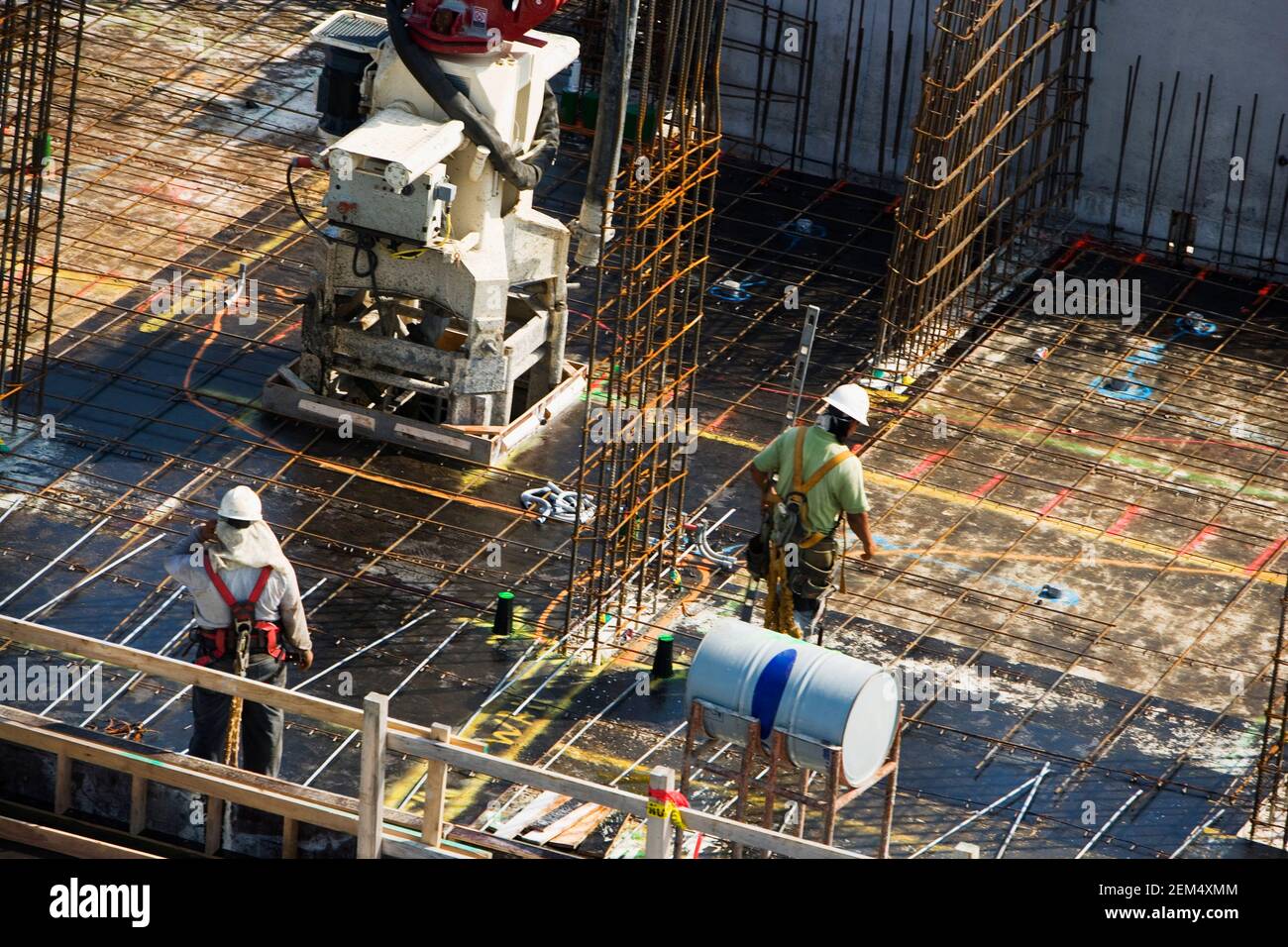 Rear view of two construction workers working at construction site hi ...