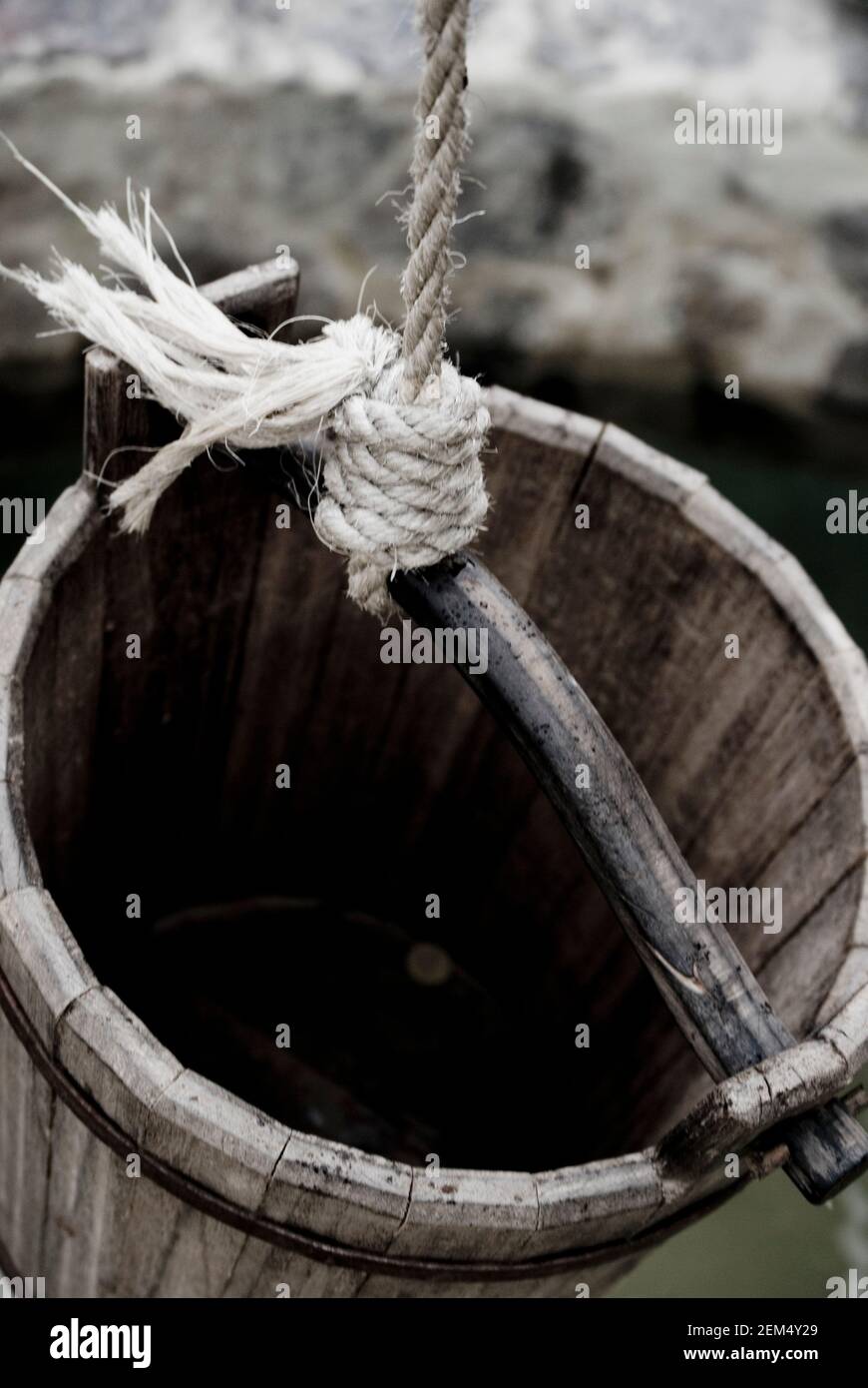 Close-up of a bucket with a rope into a well Stock Photo - Alamy