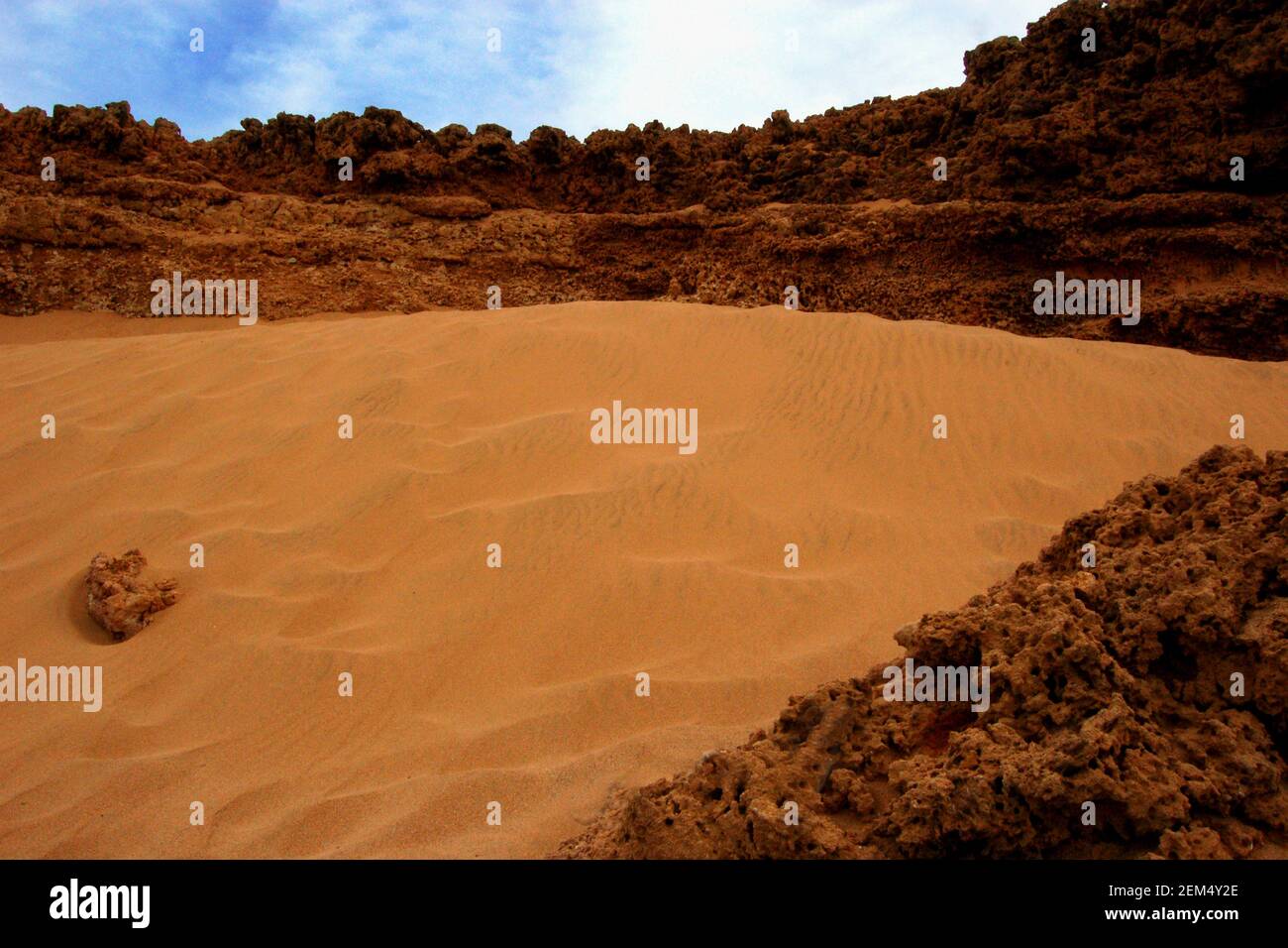 Sand dune surrounded by rock formations Stock Photo - Alamy