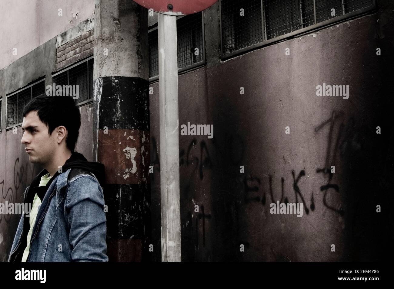 Side profile of a young man leaning against a column Stock Photo - Alamy