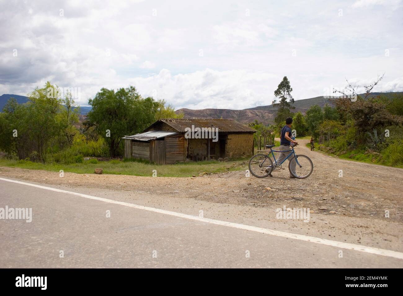 Side profile of a man walking with a bicycle Stock Photo - Alamy