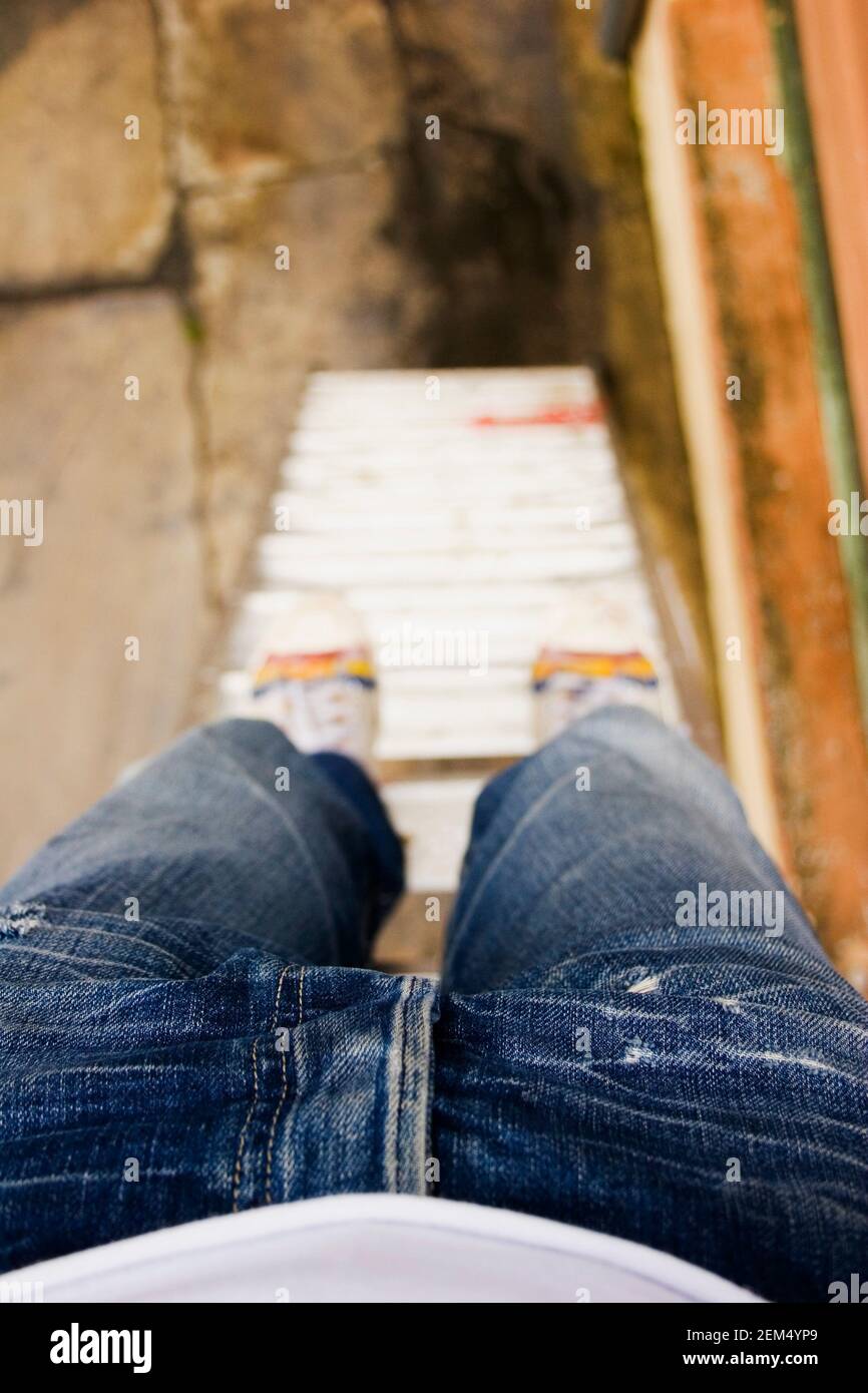 Low section view of a person standing on a ladder Stock Photo - Alamy