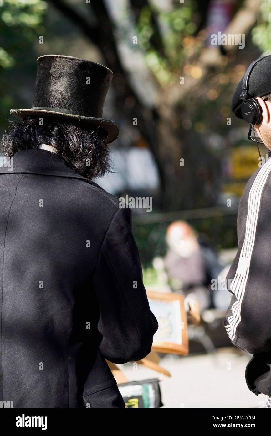 Rear view of two men standing at a market stall Stock Photo - Alamy
