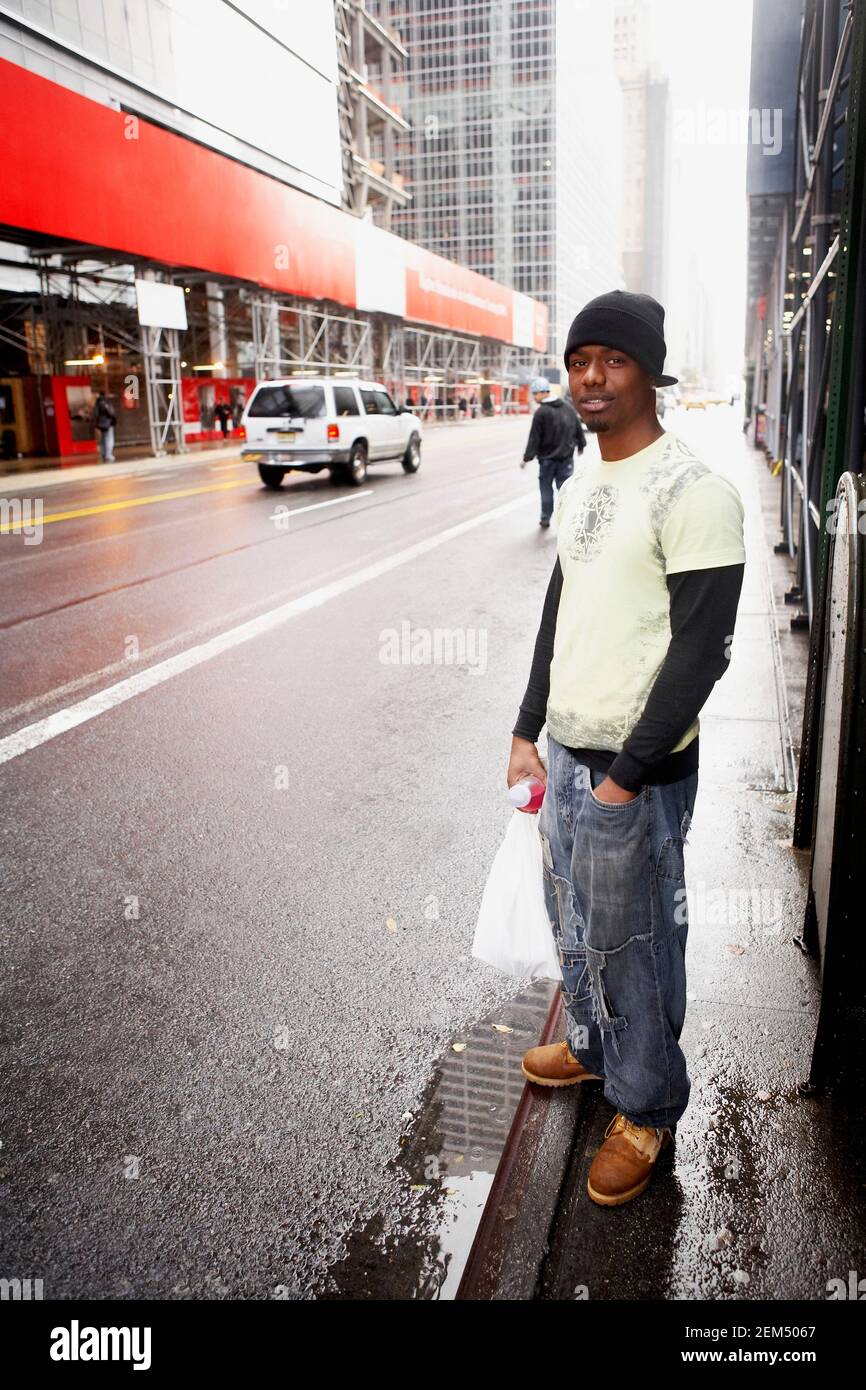 Portrait of a young man standing on the roadside Stock Photo - Alamy