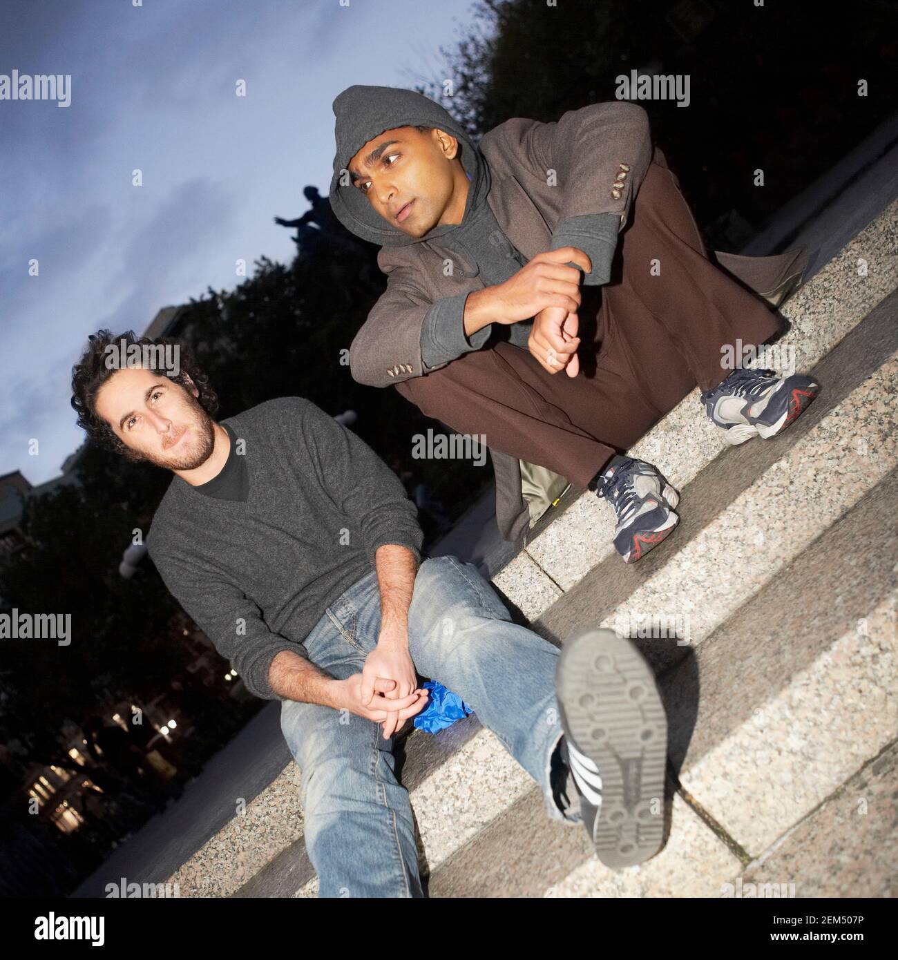 Two young men sitting on steps Stock Photo - Alamy