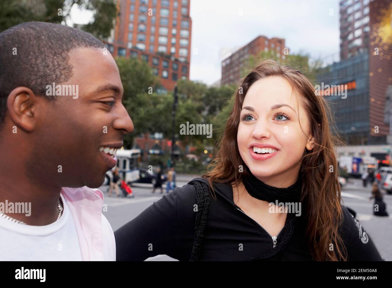 Young couple standing and smiling together Stock Photo - Alamy