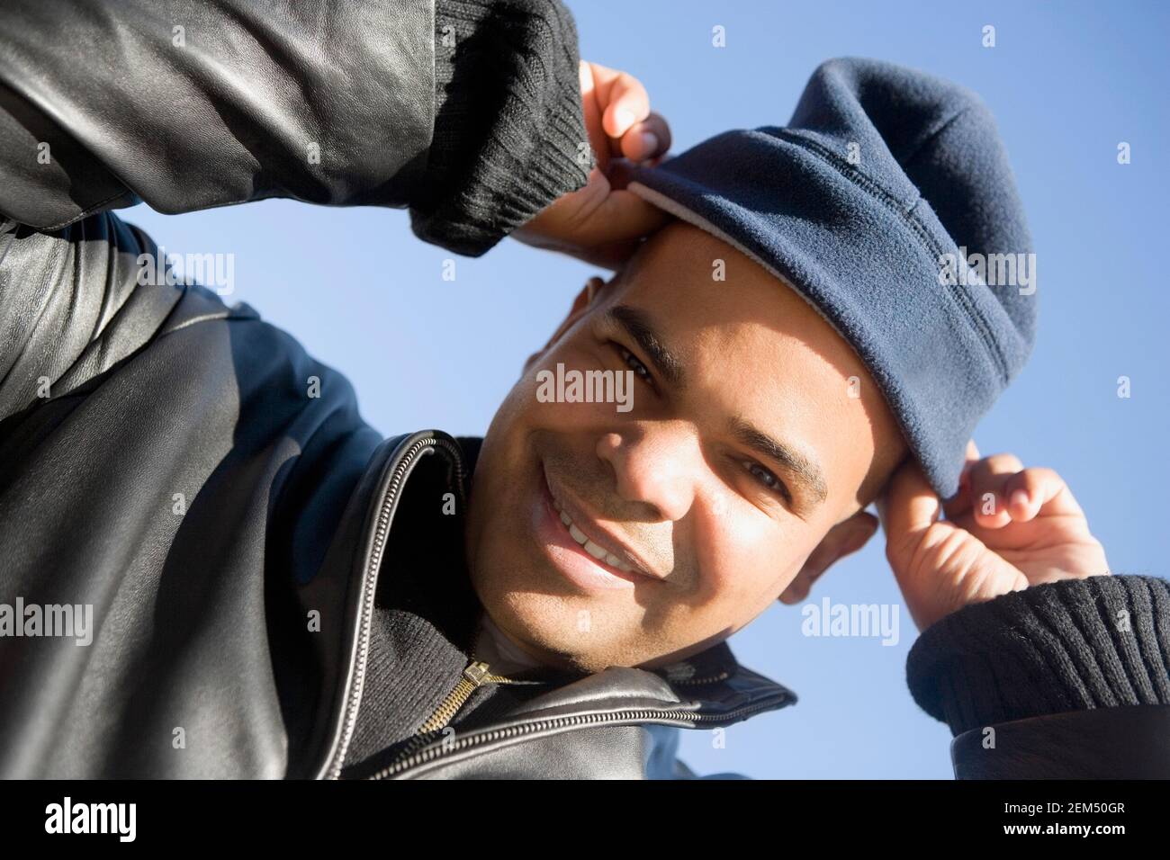 Portrait of a mid adult man adjusting his hat Stock Photo - Alamy