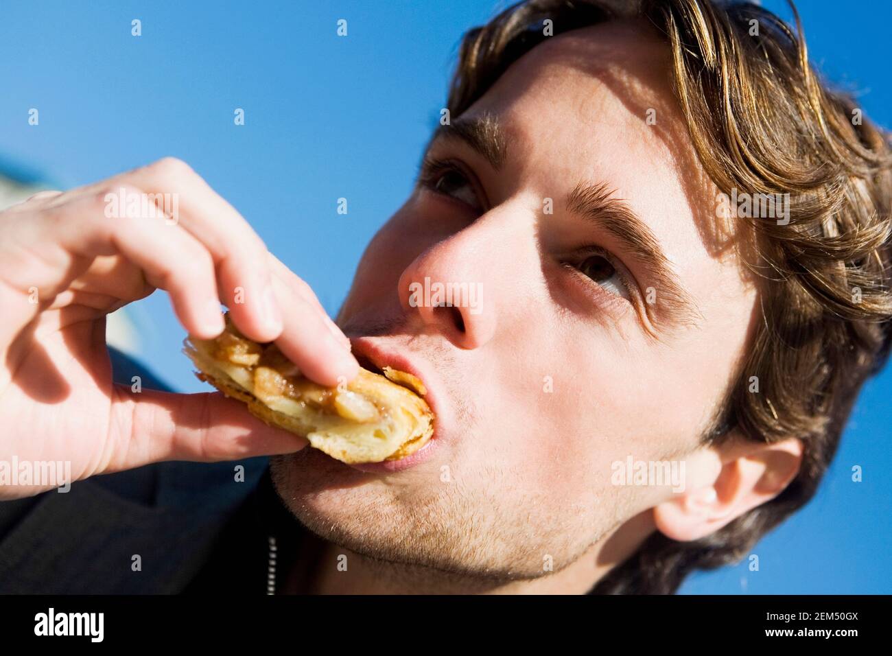 Close-up of a young man eating food Stock Photo - Alamy