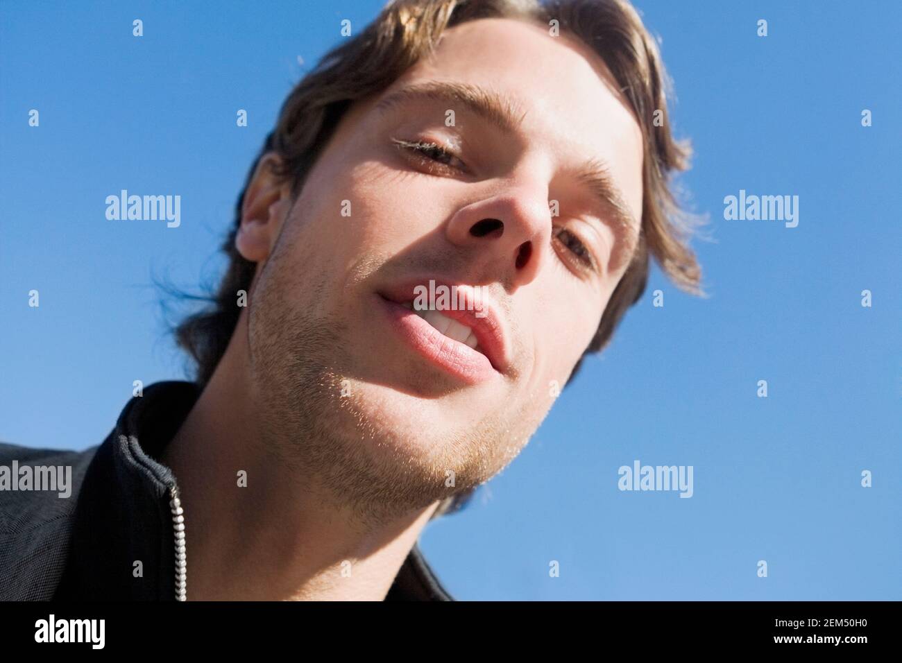 Portrait of a young man smirking Stock Photo - Alamy