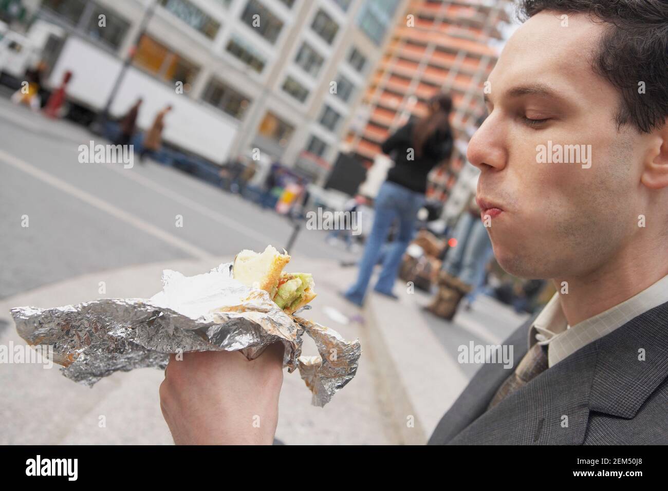 Man eating sandwich standing hi-res stock photography and images - Alamy