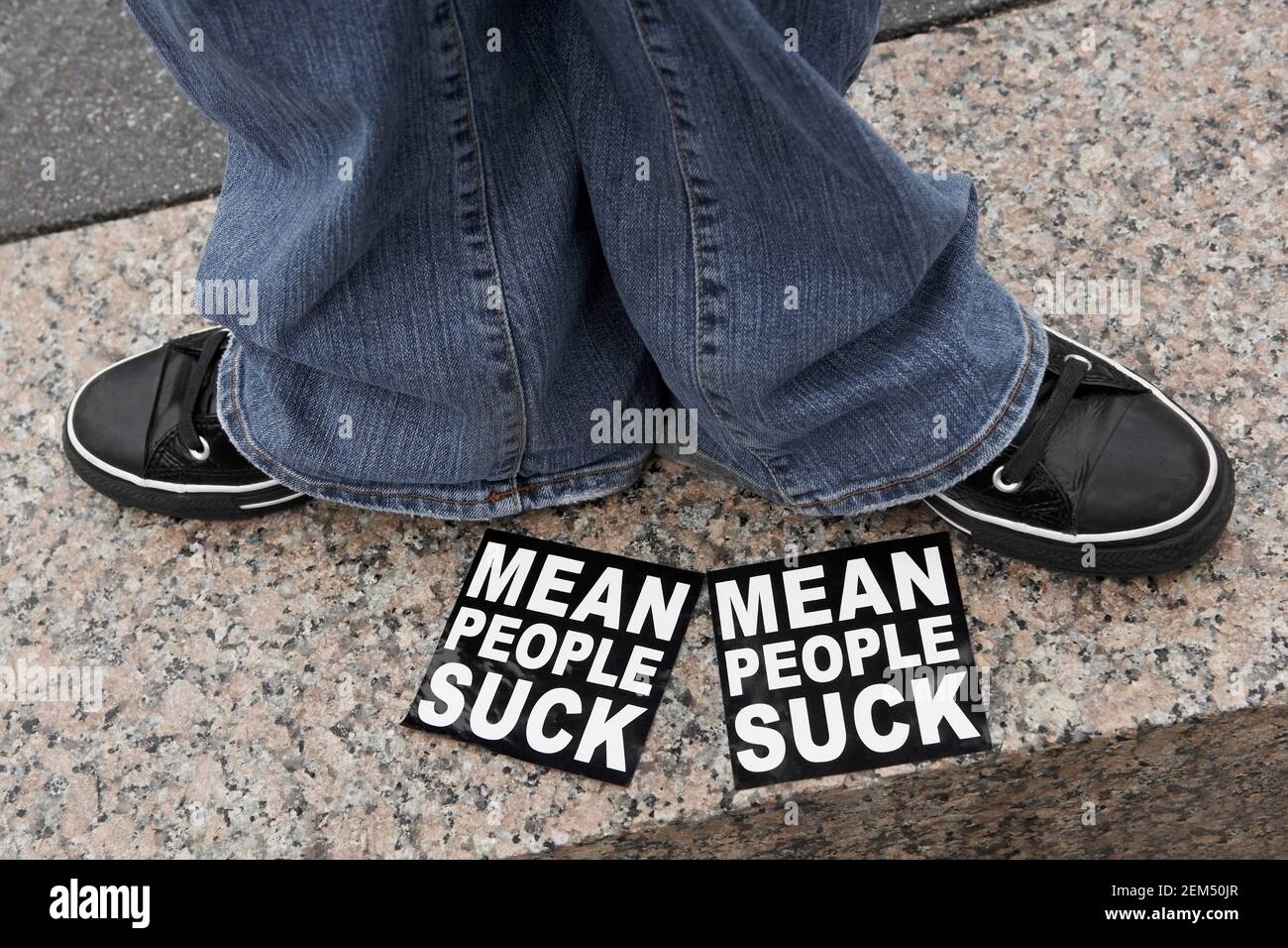 Low section view of a person standing near two placard Stock Photo - Alamy