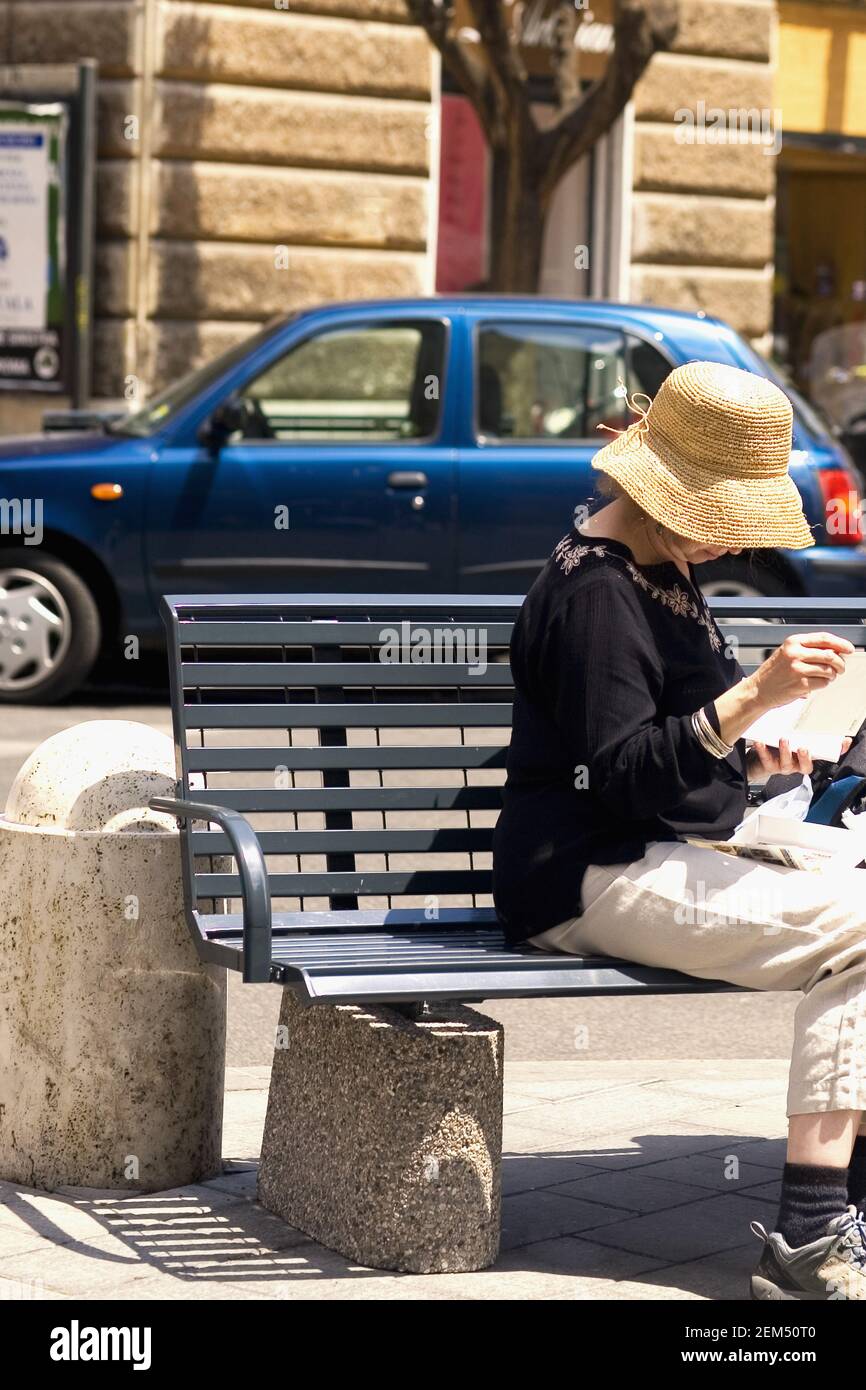 Side profile of a woman sitting on the bench Stock Photo - Alamy