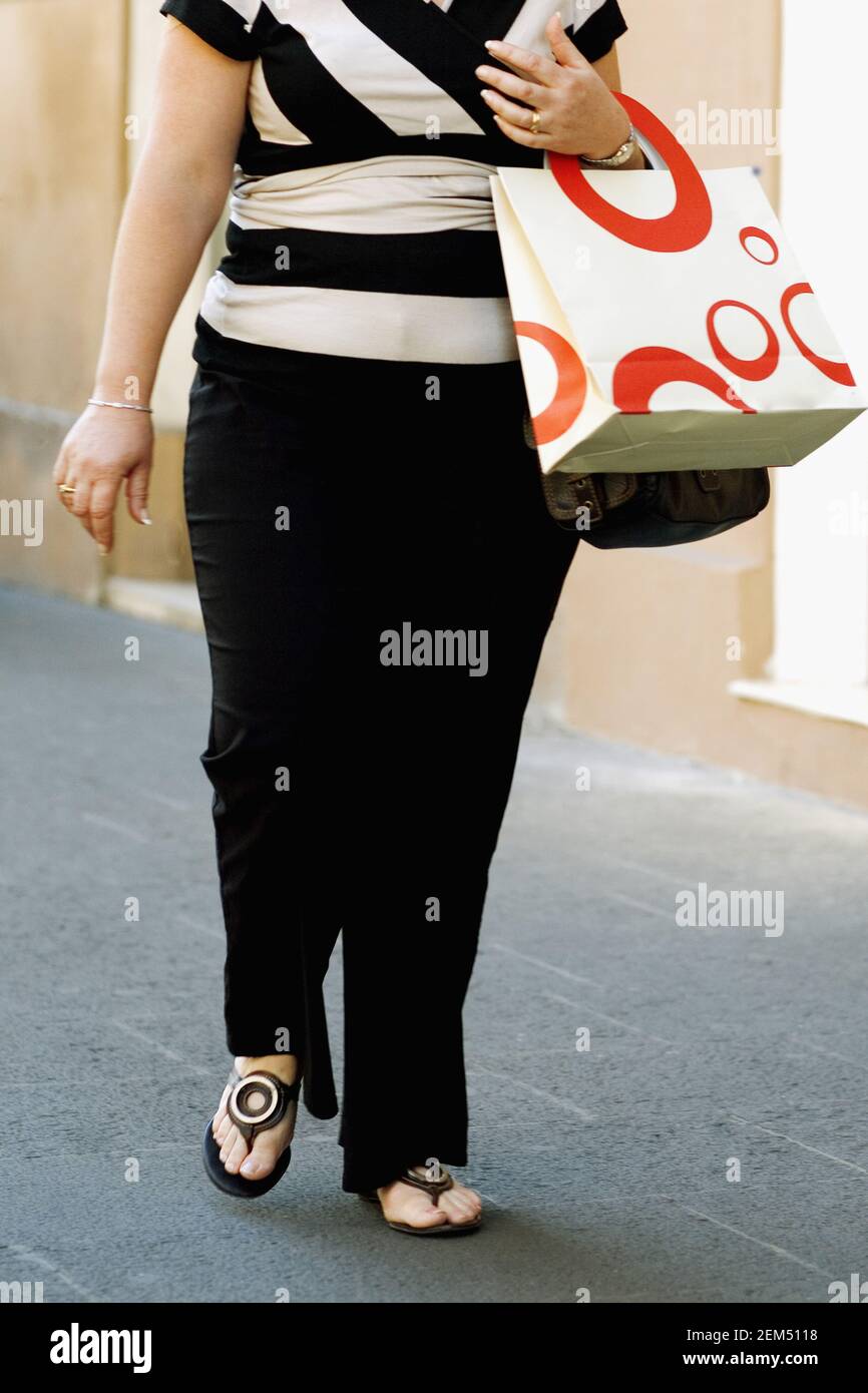 Low section view of a woman carrying hand bags and walking Stock Photo ...