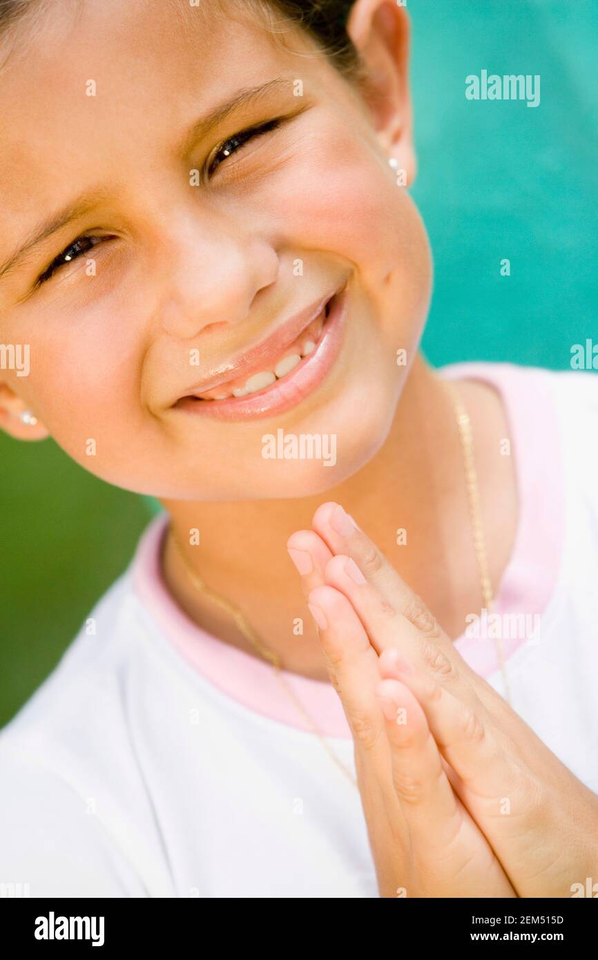 Portrait of a girl smiling in a prayer position Stock Photo - Alamy