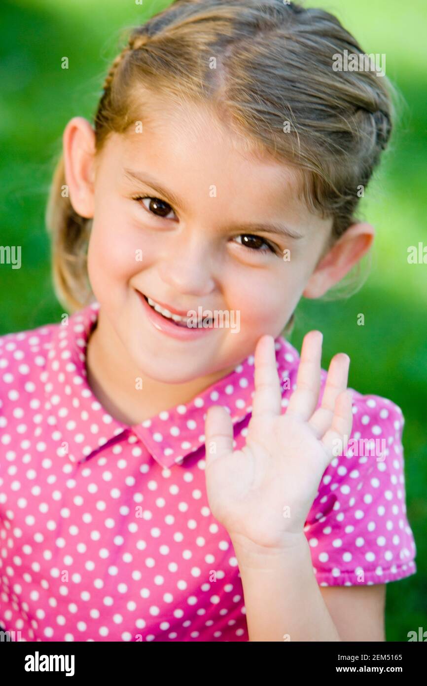 Portrait of a girl waving her hand Stock Photo - Alamy